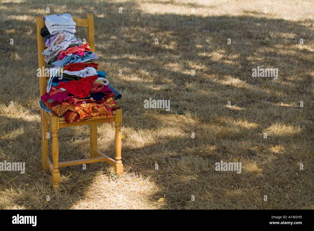 Stack of laundry on a chair in the back yard Stock Photo - Alamy