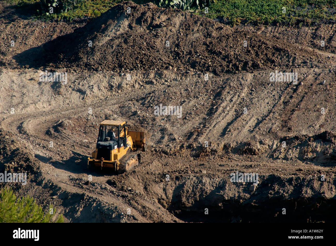 Bulldozer moving dirt on a hill Stock Photo - Alamy