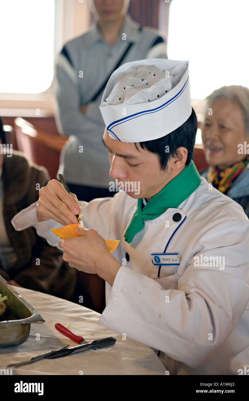 CHINA YANGTZE RIVER Chef demonstrating vegetable carving by carving a ...