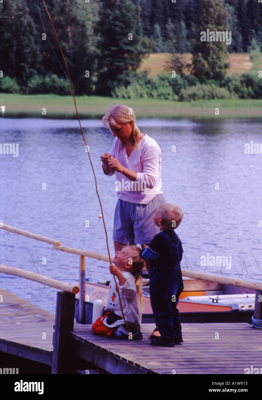 Children fishing with mother look mom i cought a fish Stock Photo - Alamy
