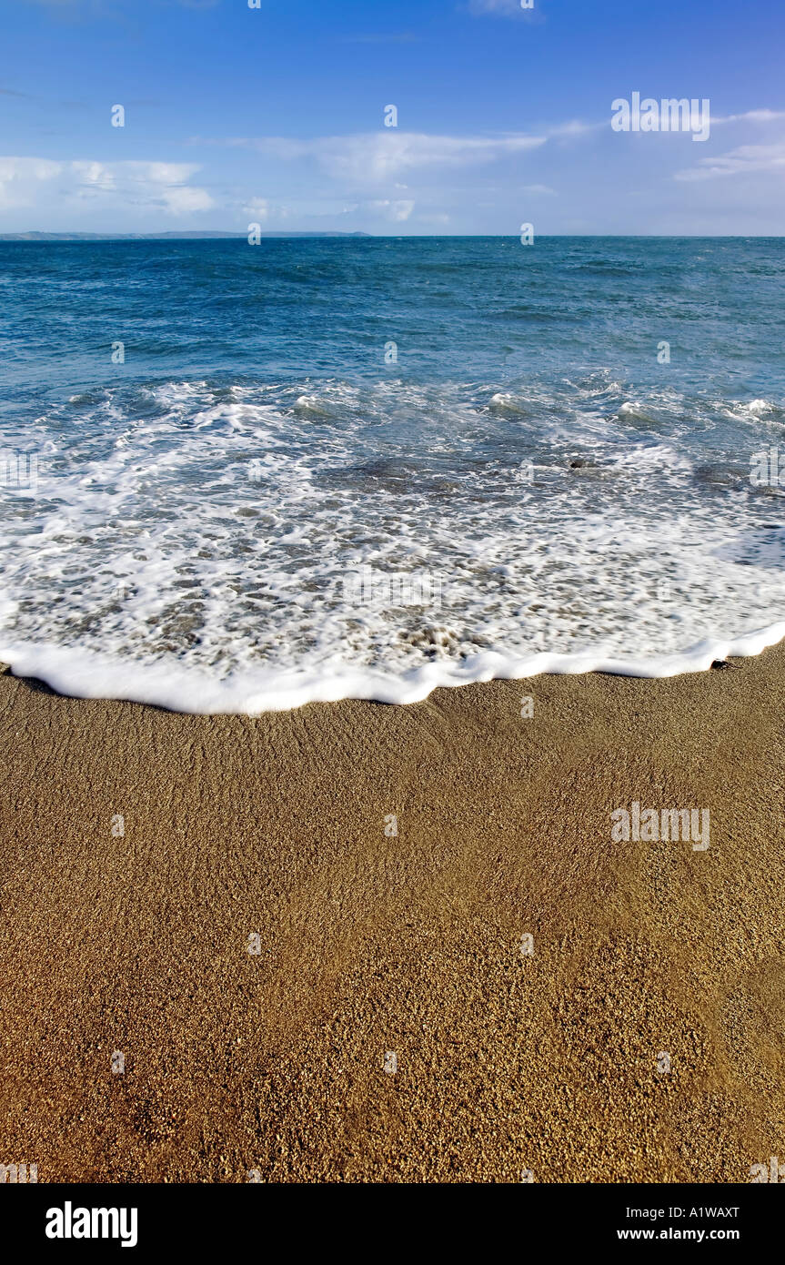 A clean wave washing over a sand beach Stock Photo - Alamy