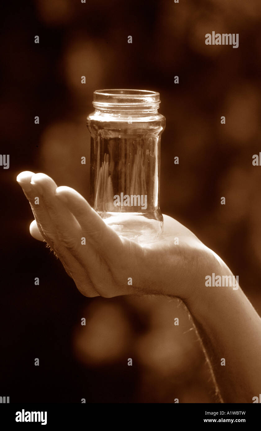 Mans Hand Holding An Empty Glass Jar ,Outside In The Daylight Stock ...