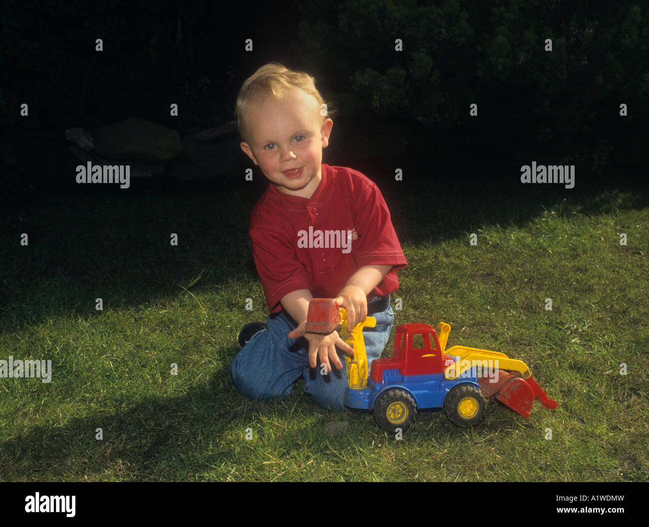 Little Boy Playing Happily With His Toy Digger,Outside On The Garden ...