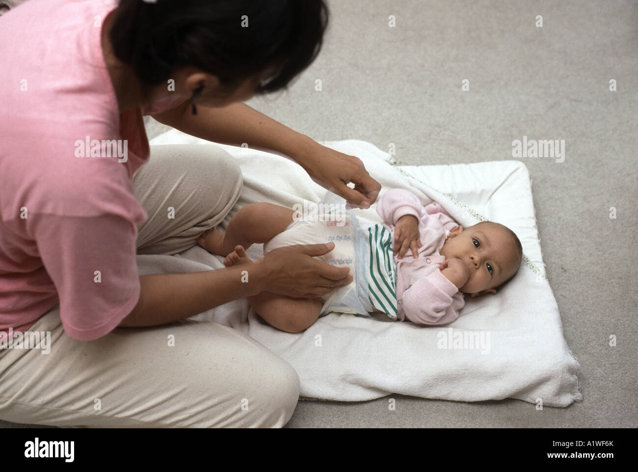 mother changing baby son's nappy Stock Photo - Alamy