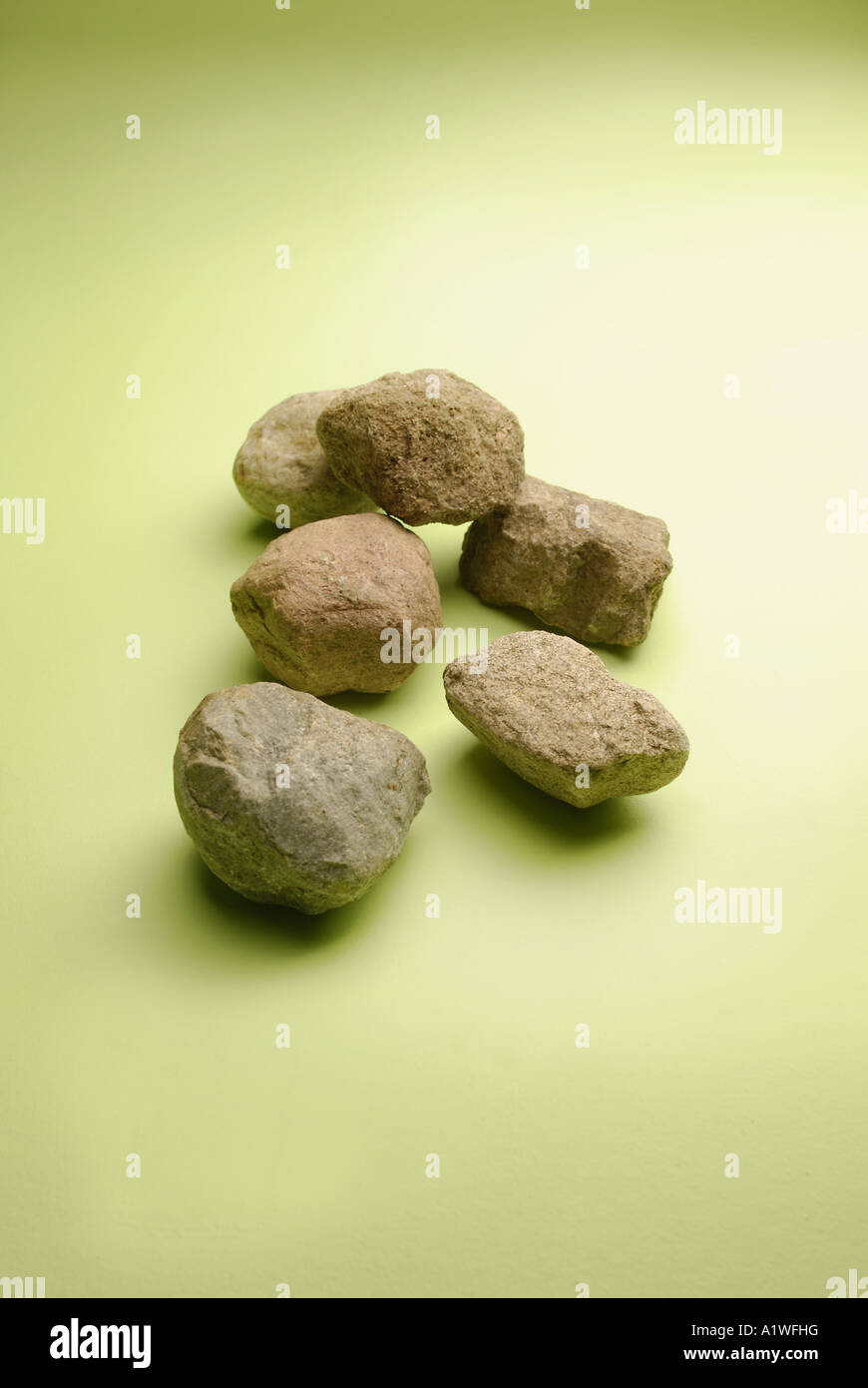 Five rocks on a green background Stock Photo - Alamy