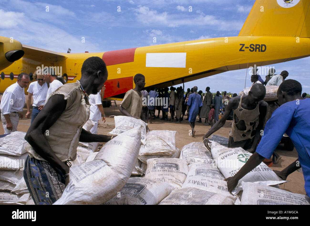 SOUTH SUDAN AUGUST 1998 FAMINE. AID WORKERS AND LOCALS UNLOAD SACKS OF ...