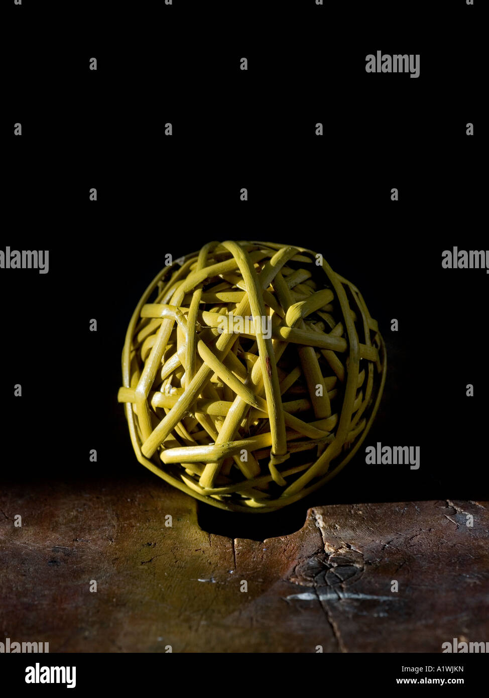 Rustic woven ball made of wicker and bamboo lying on wooden floor with ...