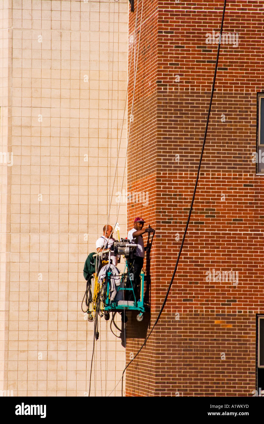 Two men repairing bricks and mortar on a building Stock Photo - Alamy