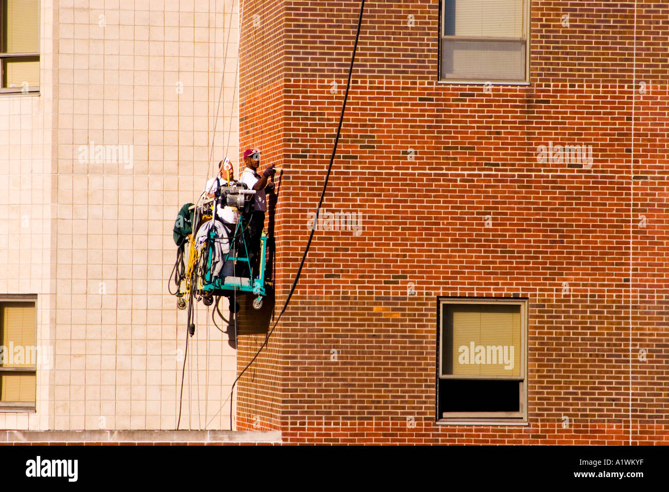 Two men repairing bricks and mortar on a building Stock Photo - Alamy