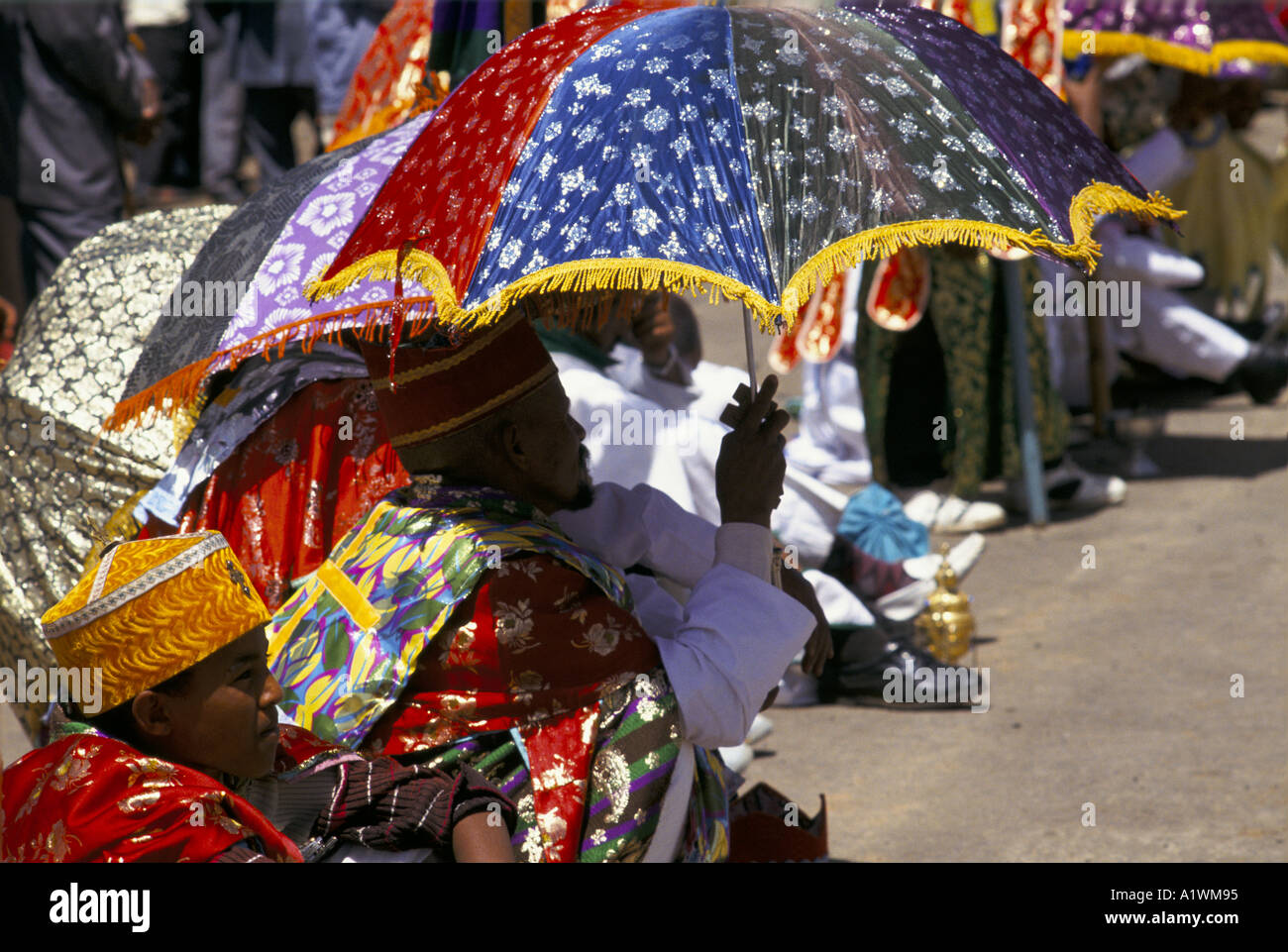 PRIESTS DRESSED IN COLOURFUL ROBES WITH GOLD DESIGN DETAIL SHELTER FROM ...
