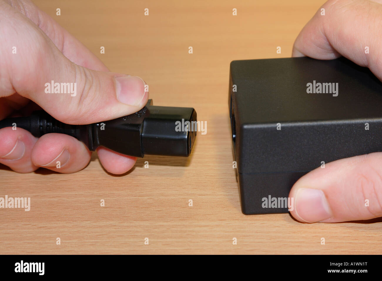 Person plugging cable into power adapter Stock Photo - Alamy