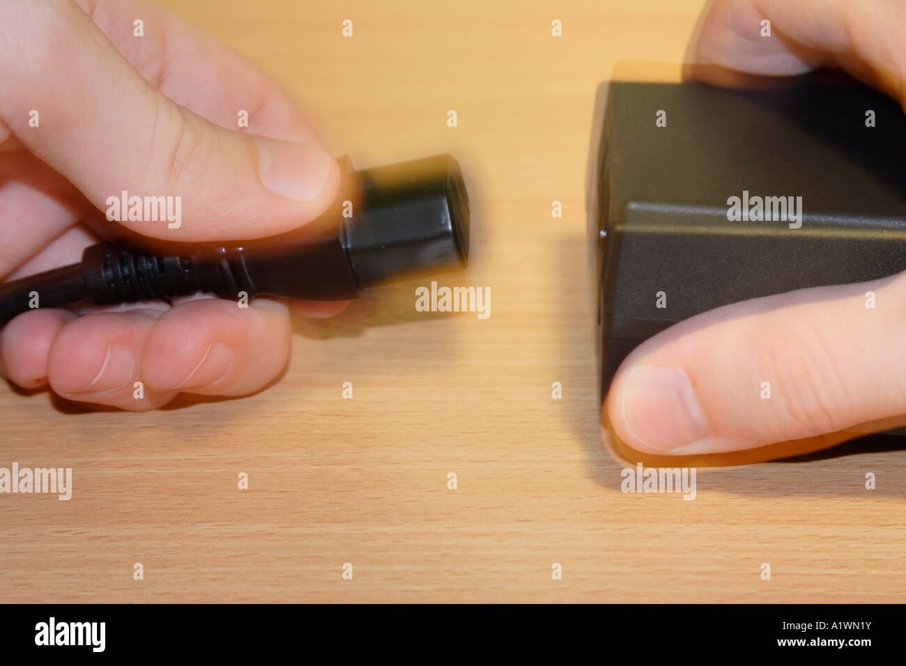 Person plugging cable into power adapter Stock Photo - Alamy