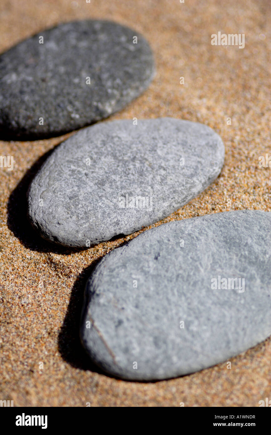 Pebbles in a line on sand Stock Photo - Alamy