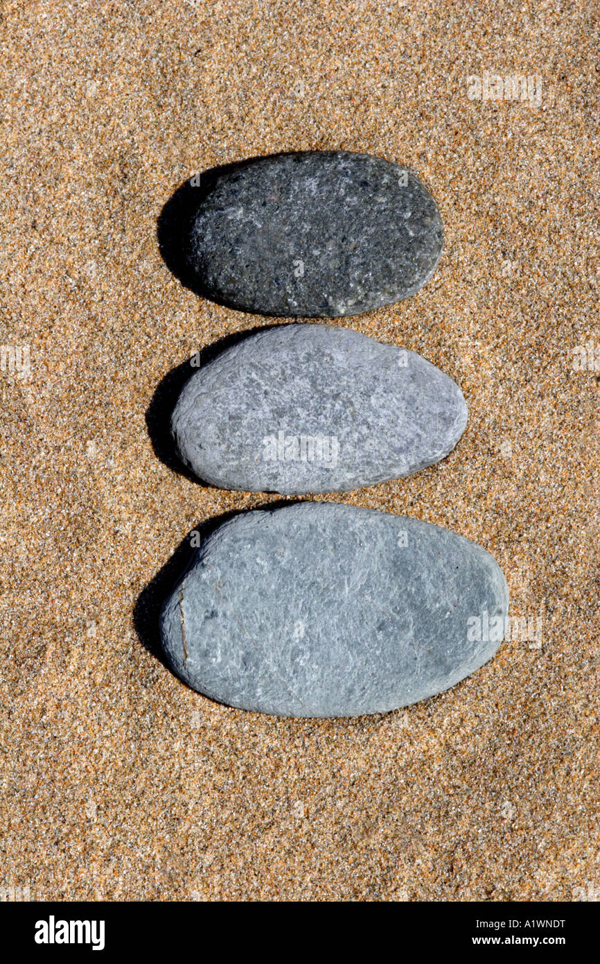Pebbles in a line on sand Stock Photo - Alamy