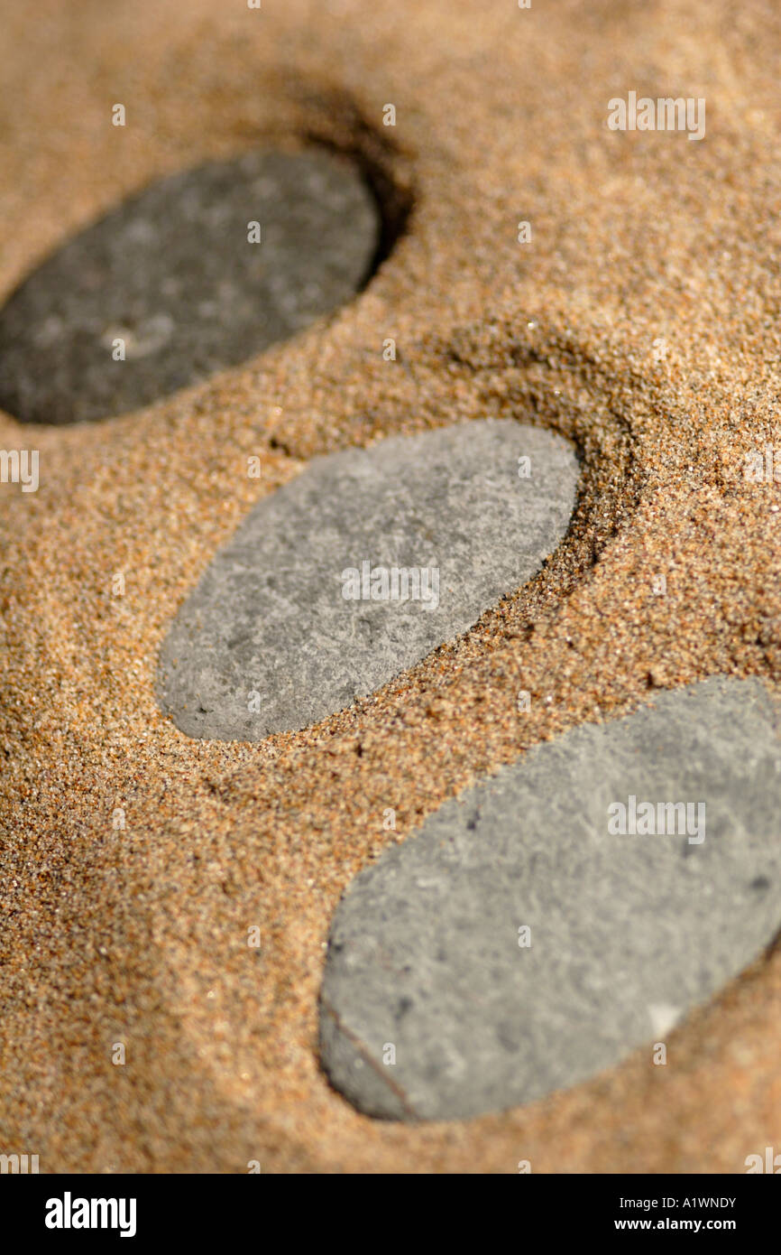 Pebbles in sand Stock Photo - Alamy