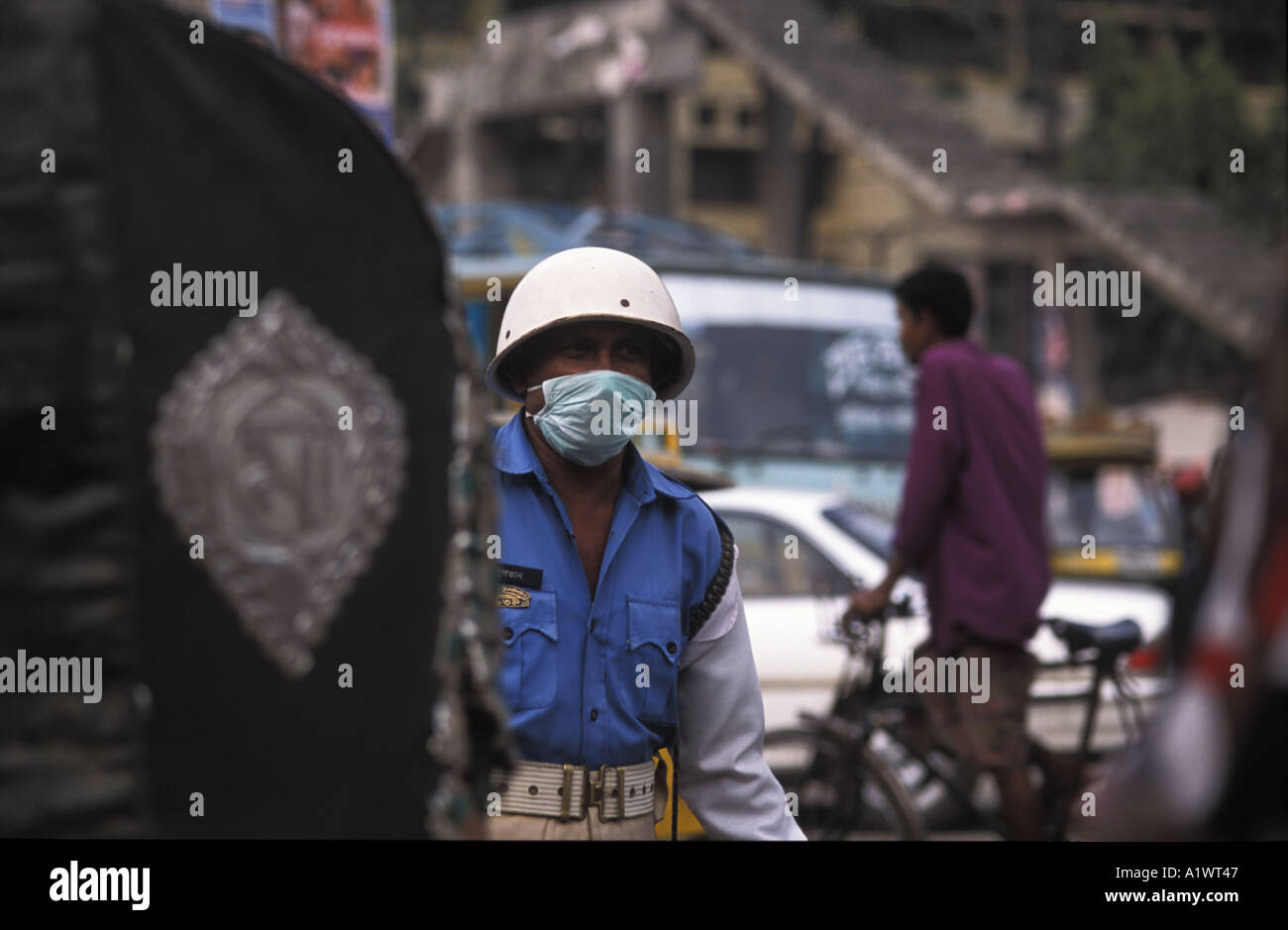 Policeman directing traffic wearing face mask to cope with pollution ...
