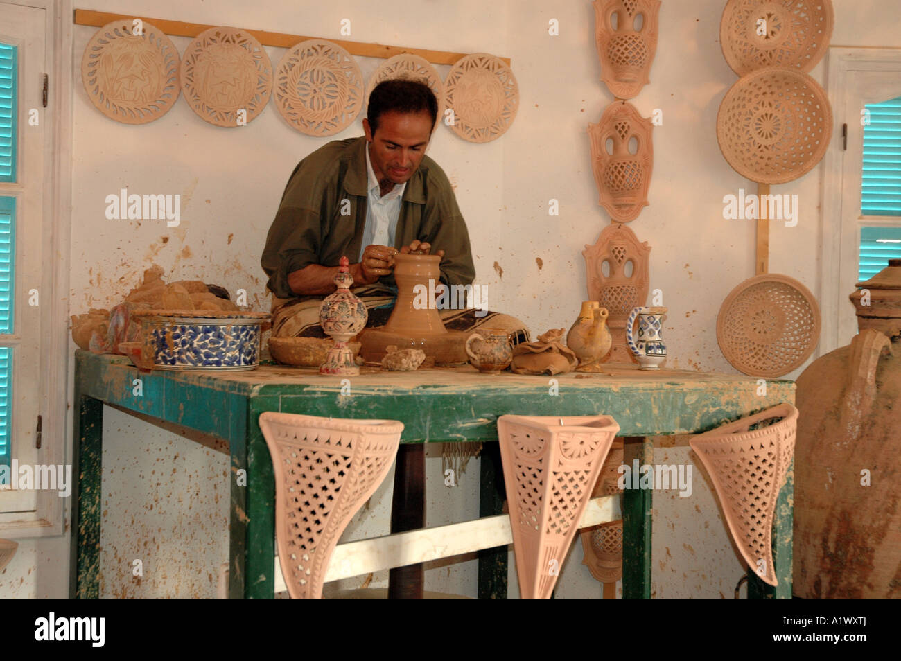 Man presenting his work in pottery workshop in Guellala town on Djerba ...