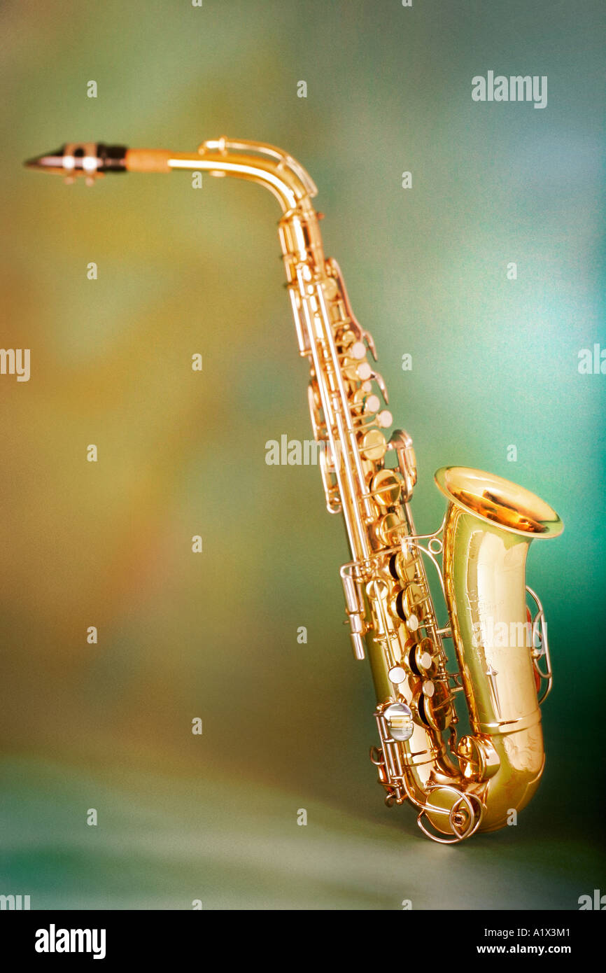 still life of saxophone against bluish green and yellow background ...