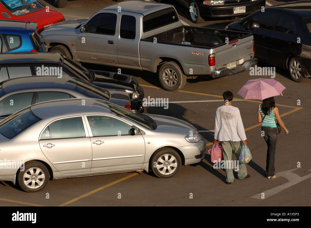 Couple in a busy car park in Bangkok Thailand Stock Photo - Alamy