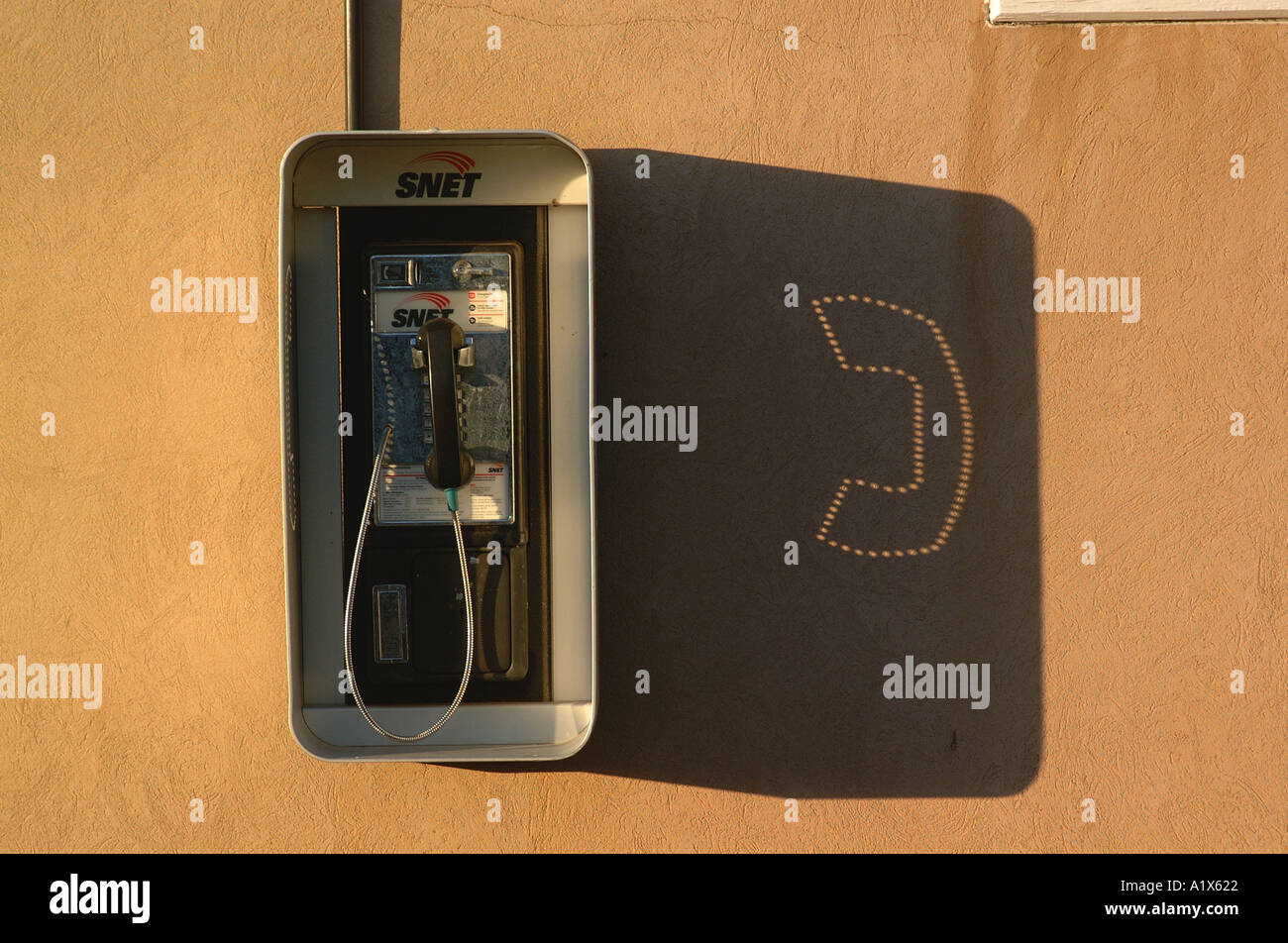 coin operated pay telephone on wall with shadow Stock Photo - Alamy