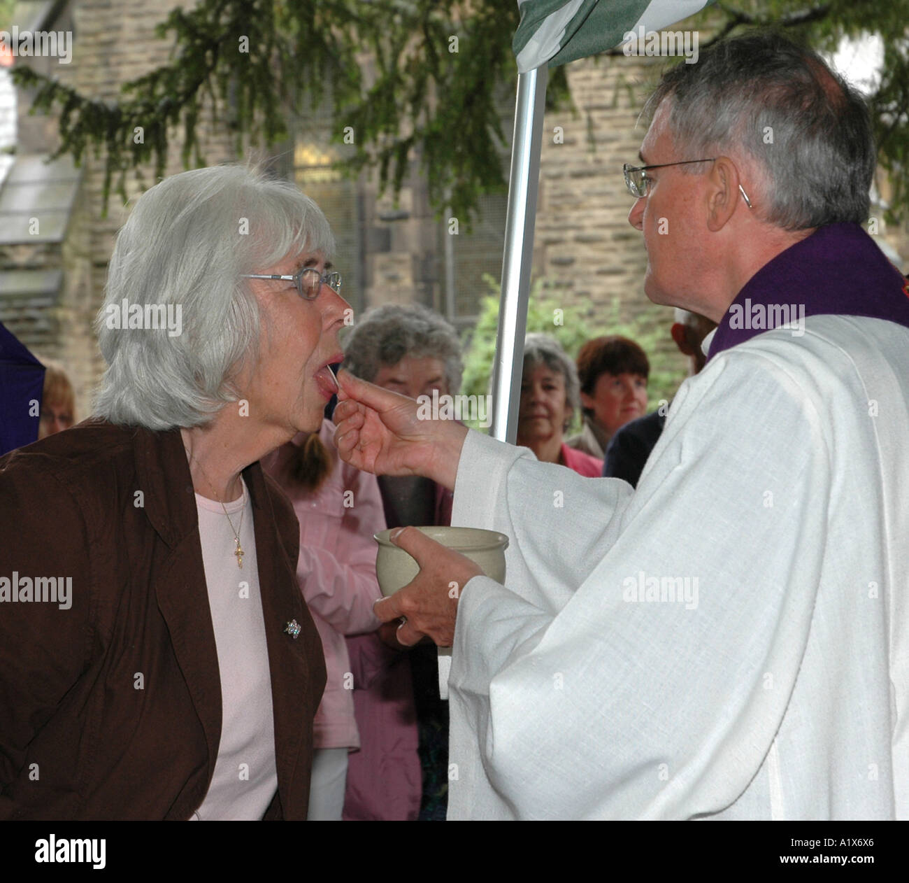 Priest gives woman communion hi-res stock photography and images - Alamy