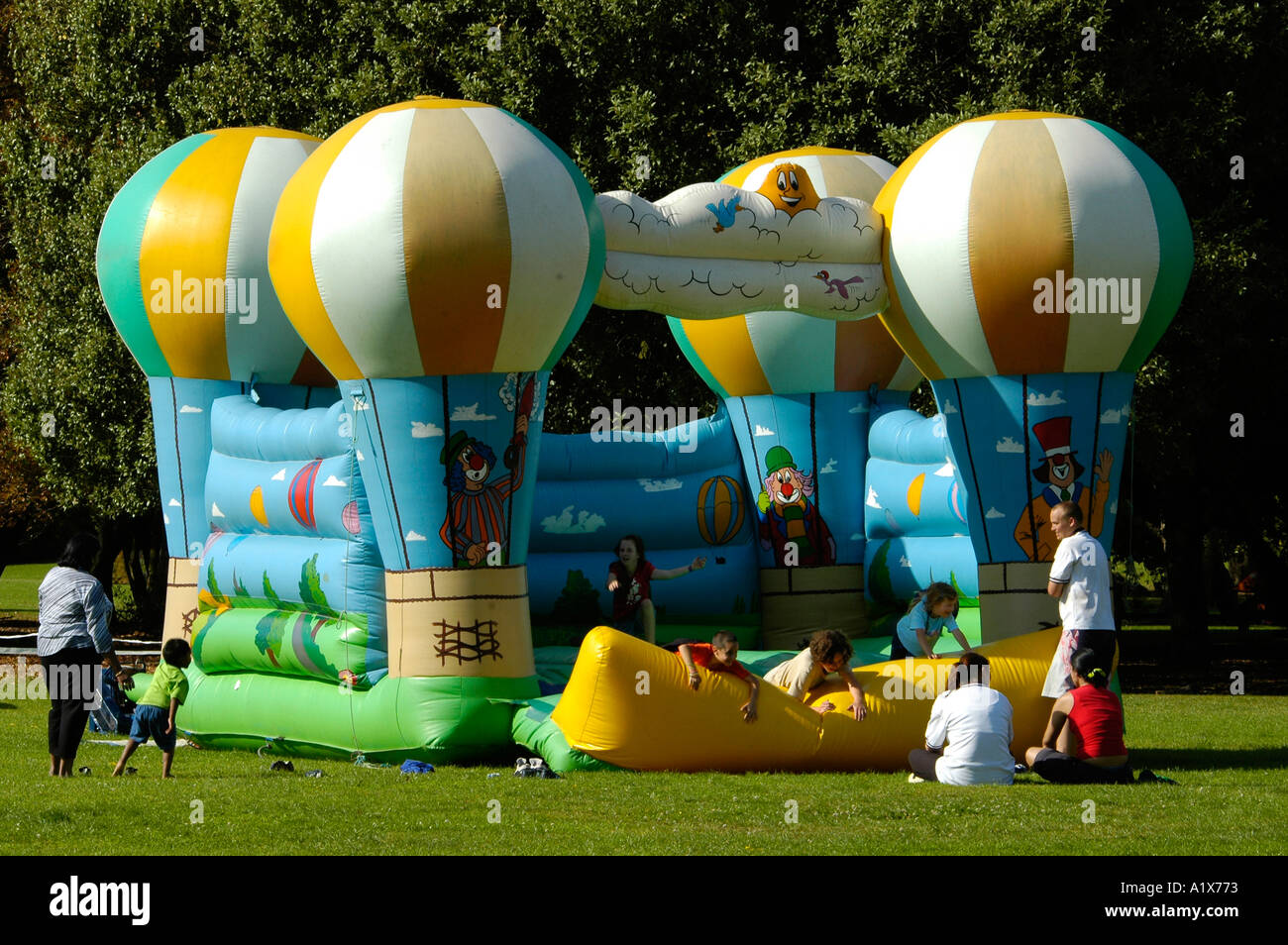 Children playing on a bouncy castle built to look like four hot air ...