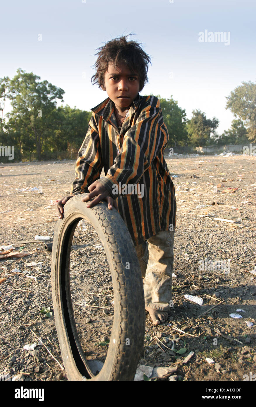 Young Indian boy playing with a tyre Stock Photo - Alamy