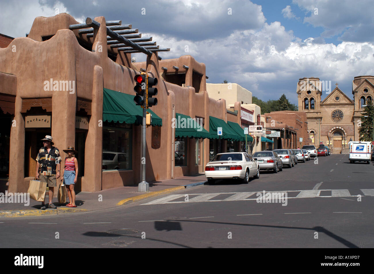 Couple of tourists standing on juncion in front of adobe style ...