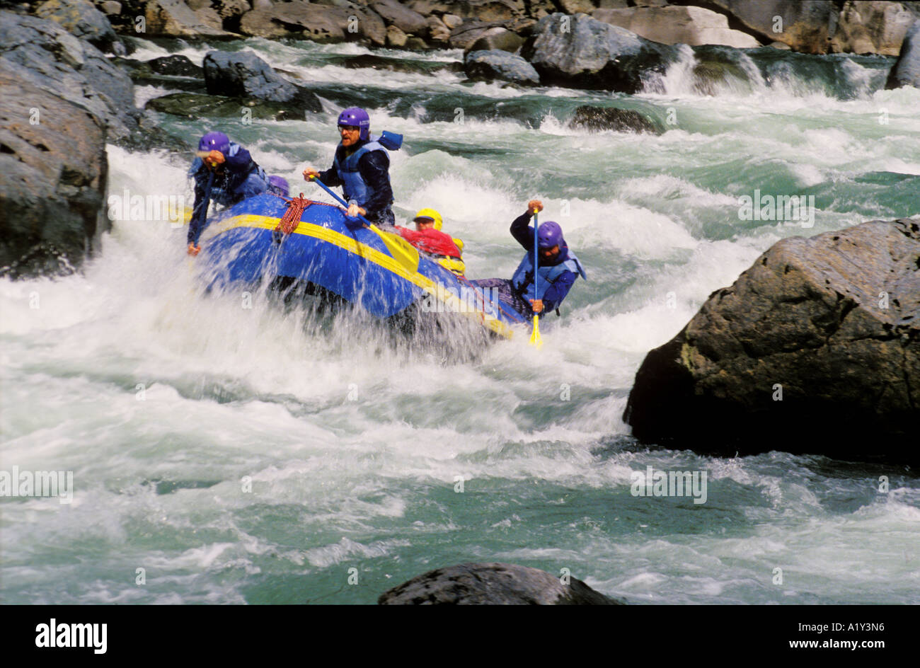 River rafters paddle through boulders and roaring rapids Stock Photo ...