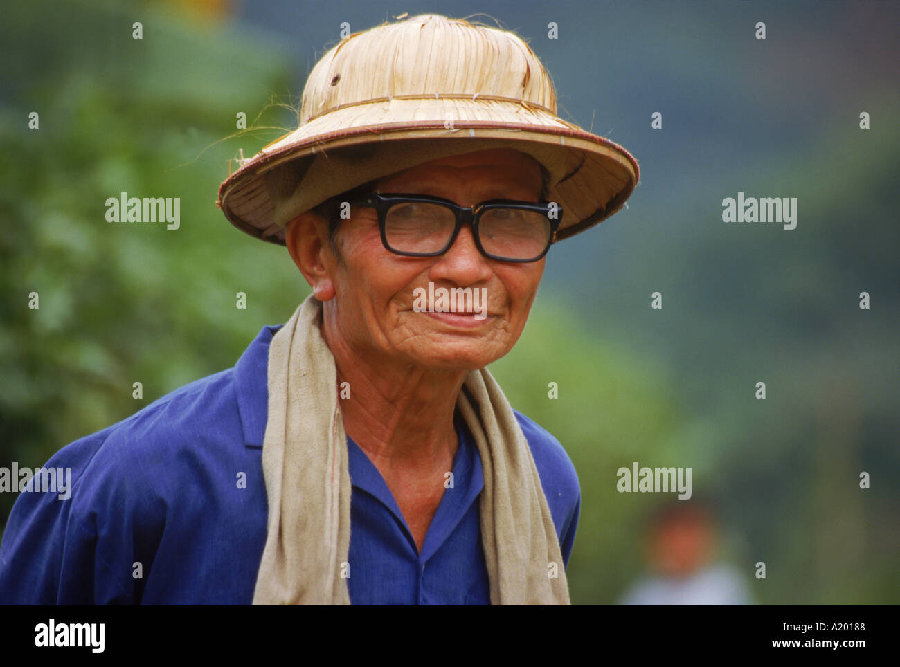 Portrait of an old man with glasses and rafia hat in Vietnam Asia J ...