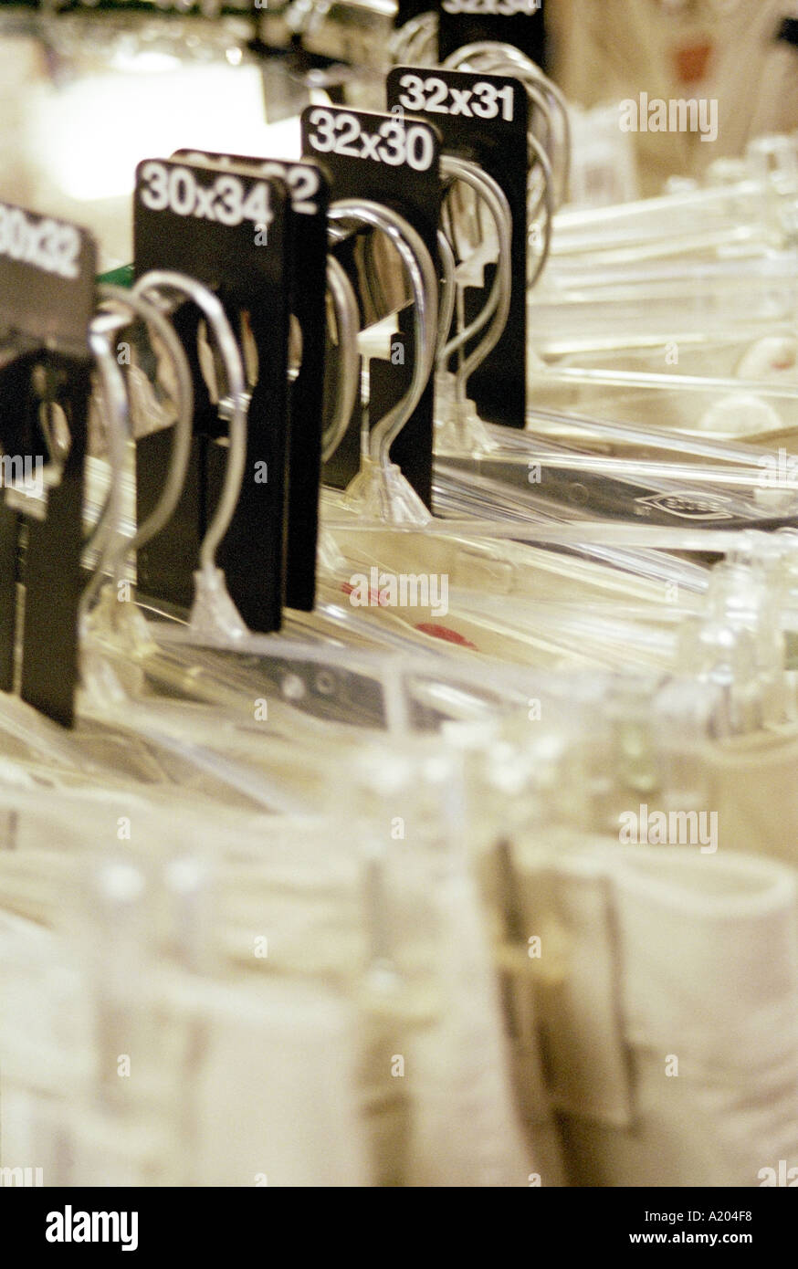 Pants hanging on rack in retail department store Stock Photo - Alamy