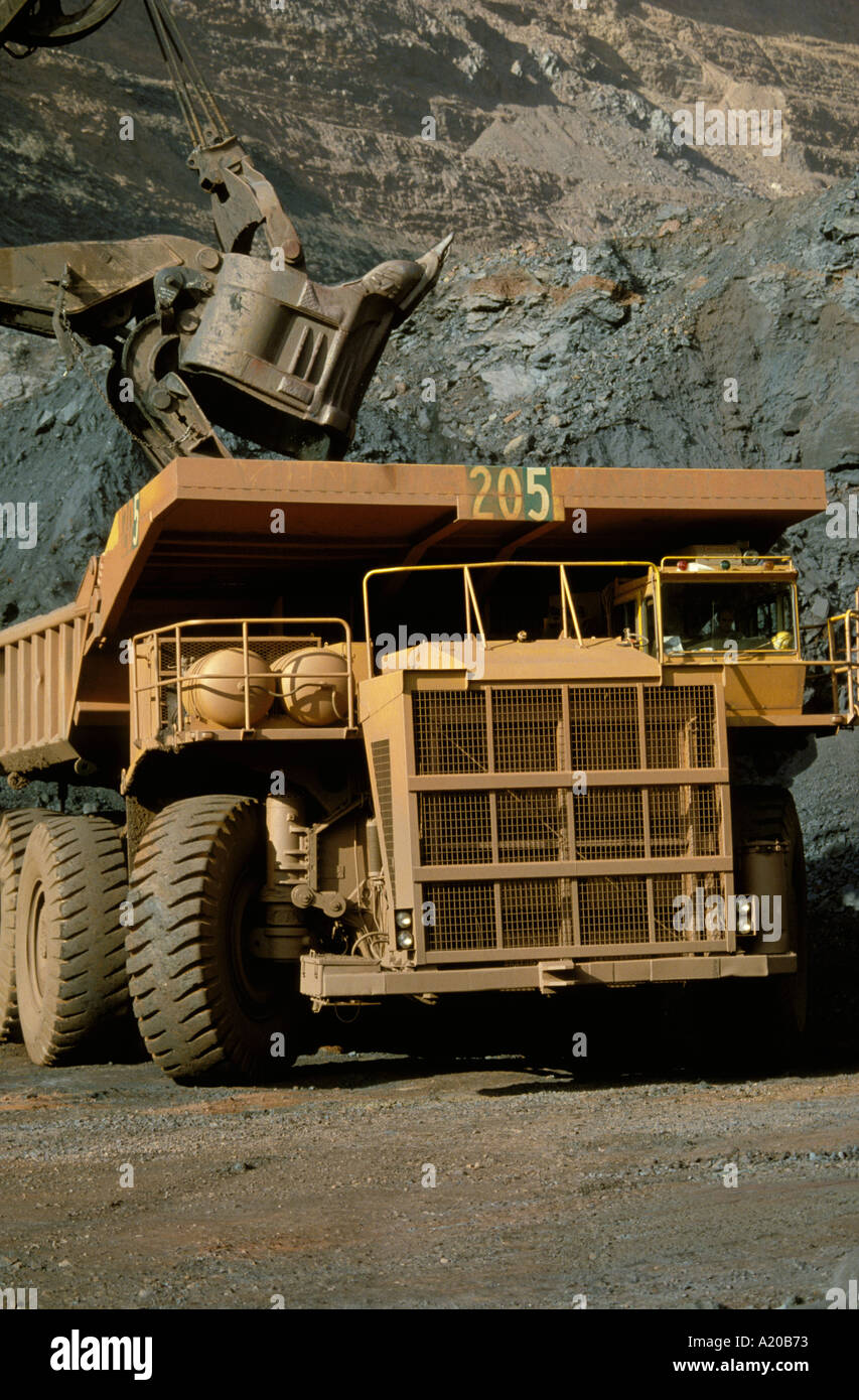 Heavy dump truck being loaded in mine Stock Photo - Alamy