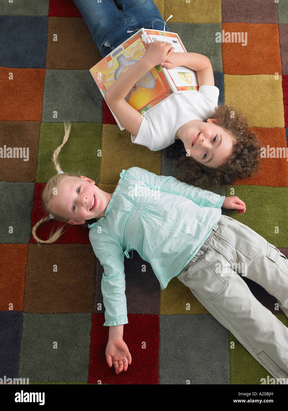 Two girls lying down on library floor, view from above Stock Photo - Alamy
