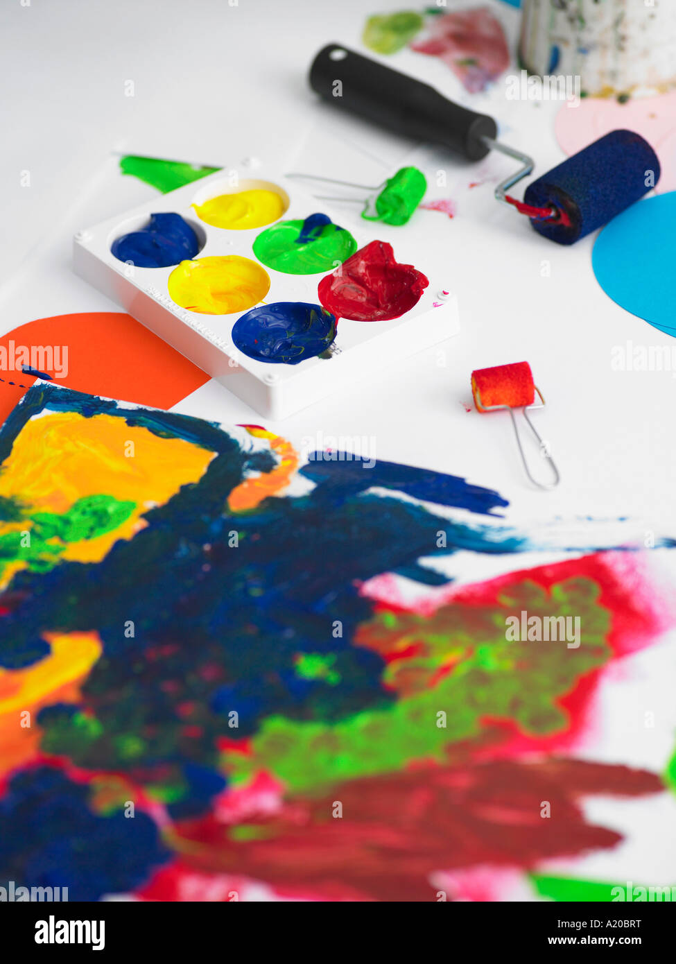 Paints and painting rollers lying next to painting, elevated view Stock ...