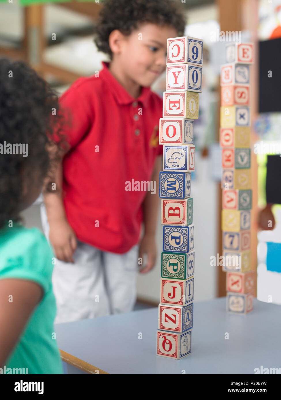 Boy playing with alphabet blocks in classroom Stock Photo - Alamy
