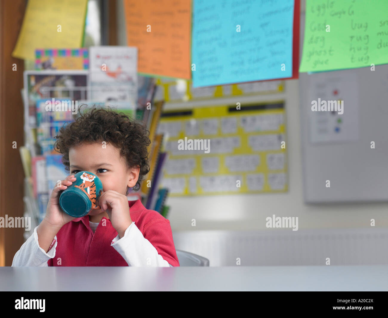 Boy drinking from cup in classroom Stock Photo - Alamy