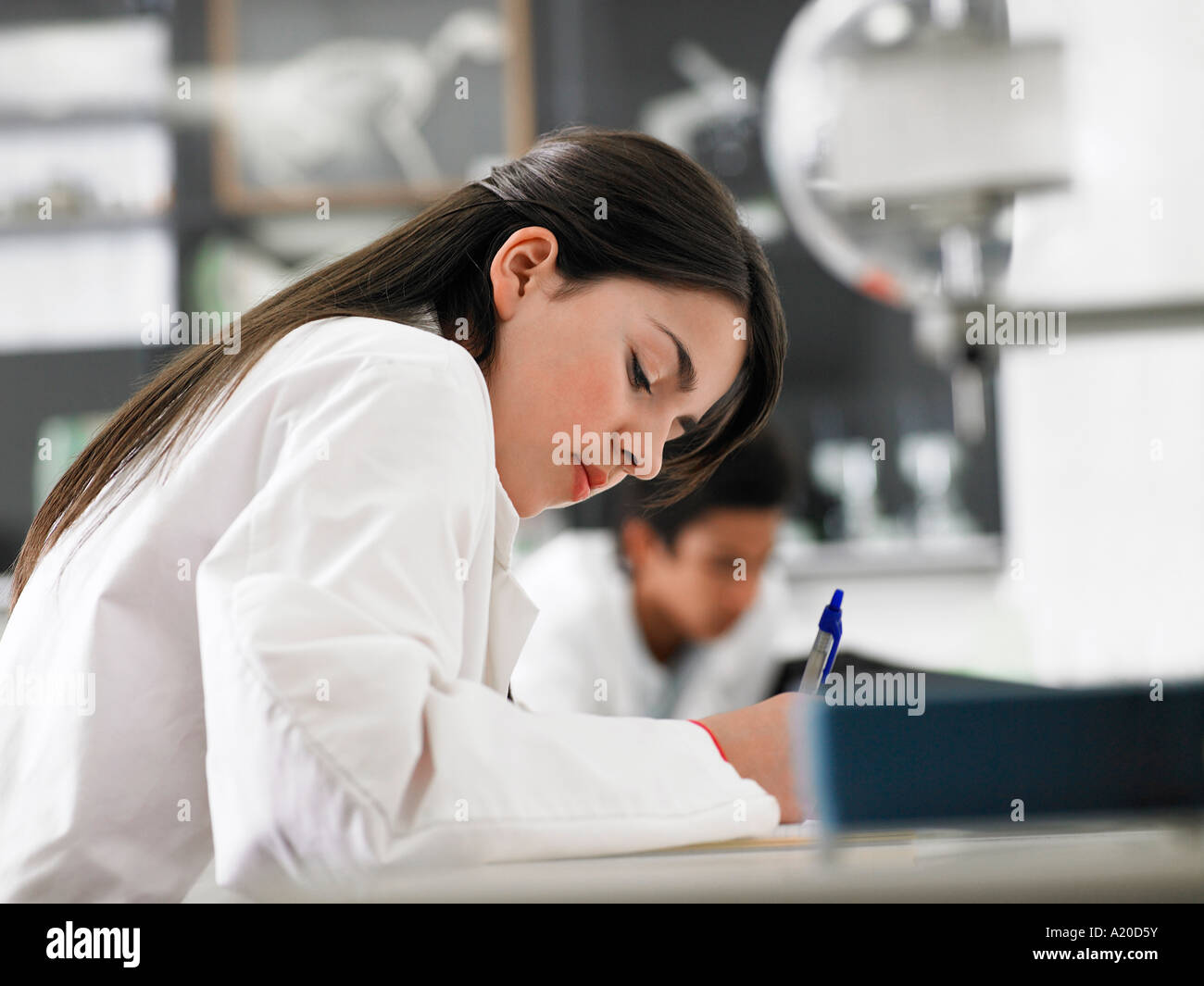 Teenager taking notes in science class Stock Photo - Alamy
