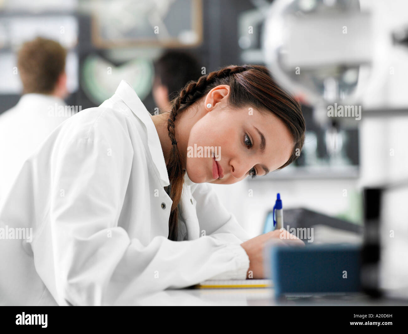 Teenager writing in science class Stock Photo - Alamy