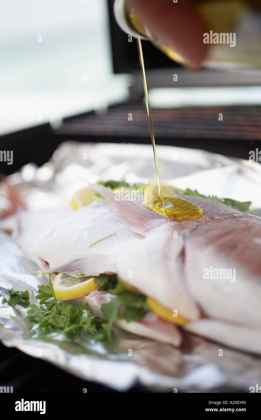 Pouring oil over Fish on Grill Stock Photo - Alamy