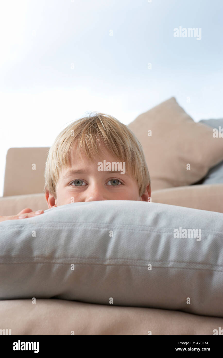 Young Boy Hiding Behind Pillows and cushions Stock Photo - Alamy