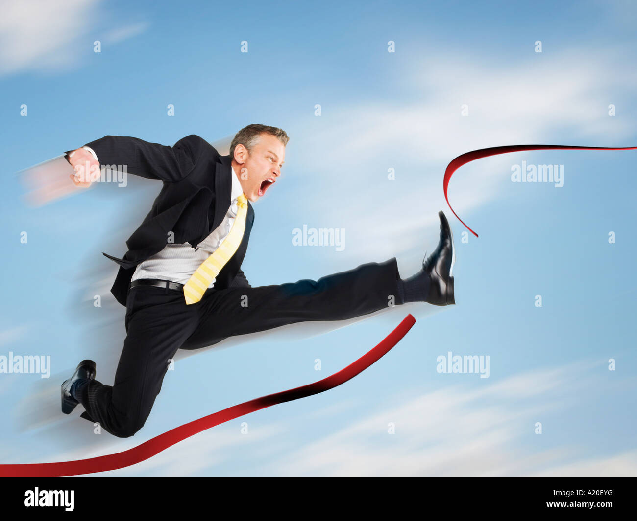 Business man jumping through red tape, digital composite Stock Photo ...