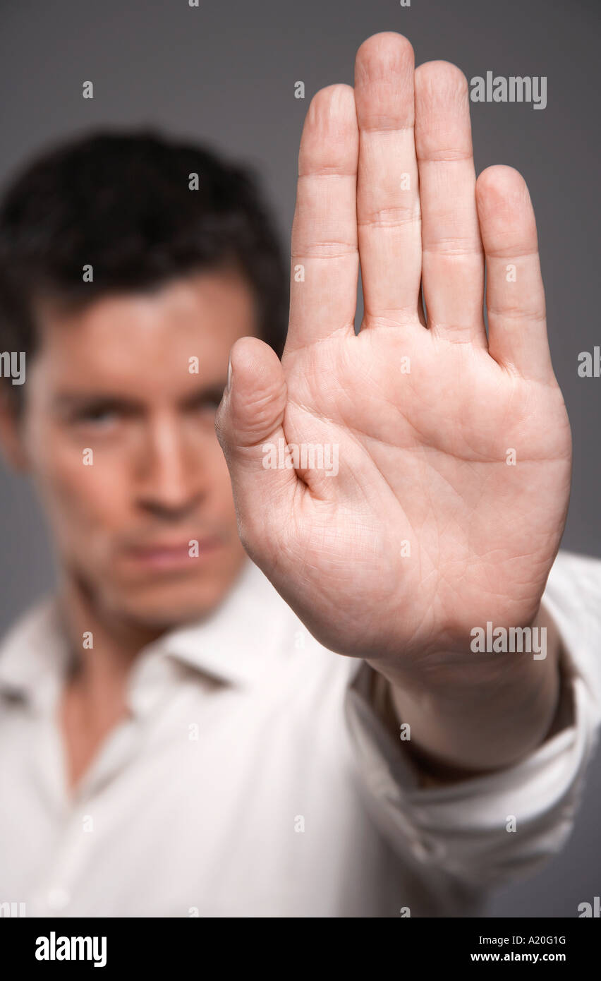 Mid-adult man holding up hand, focus on hand Stock Photo - Alamy