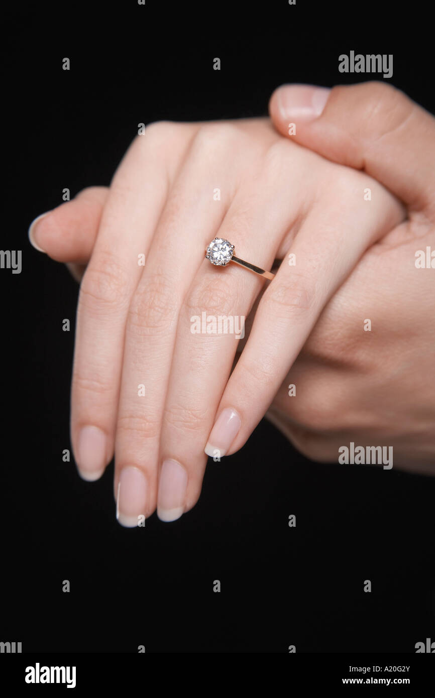 Man holding woman's hand displaying engagement ring, close up of hand ...