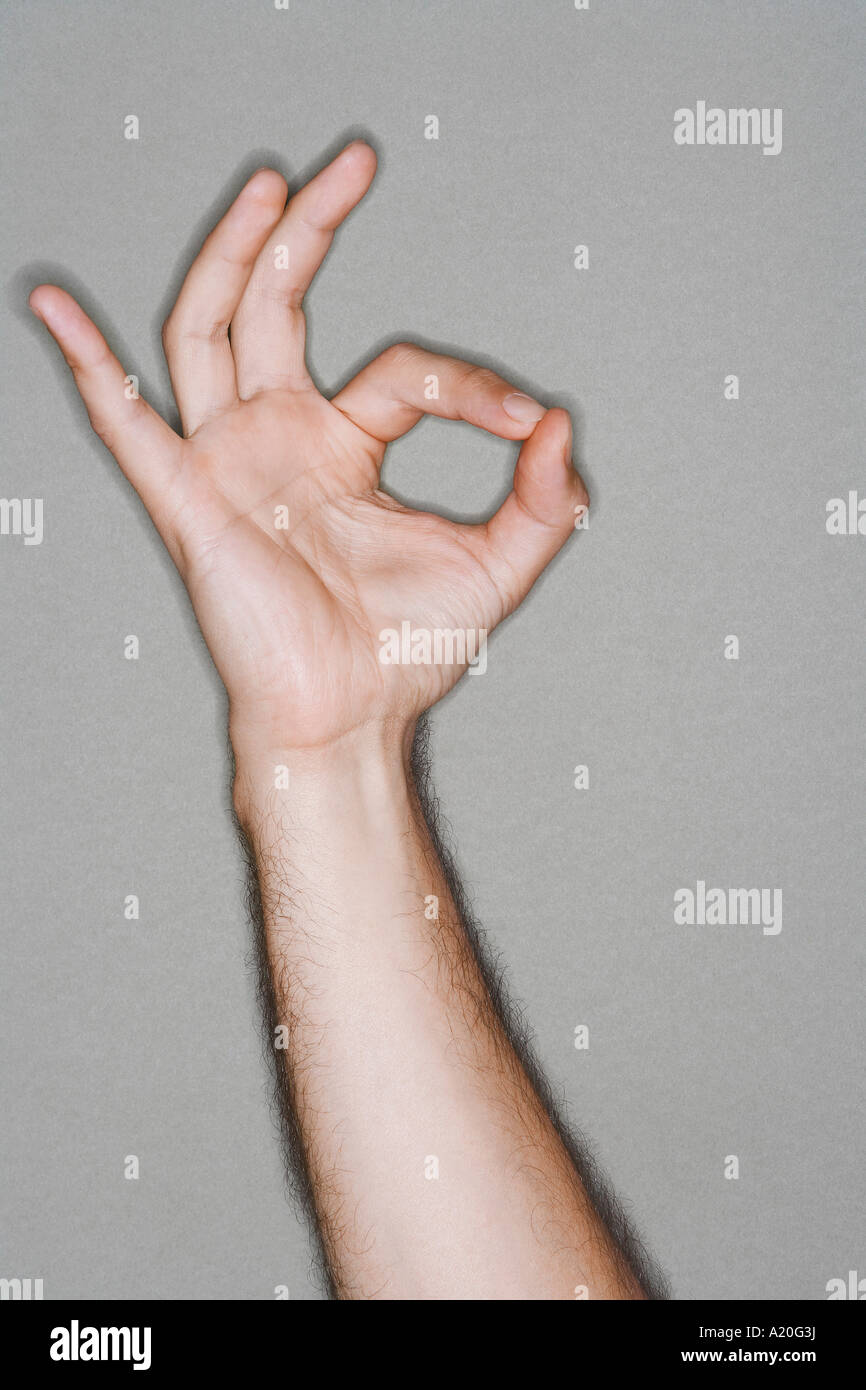 Man making okay sign, arm raised, close up on hand Stock Photo - Alamy