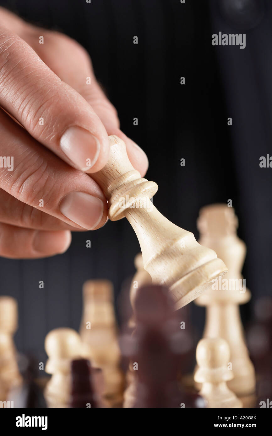 Man playing chess, close-up of hand holding piece Stock Photo - Alamy