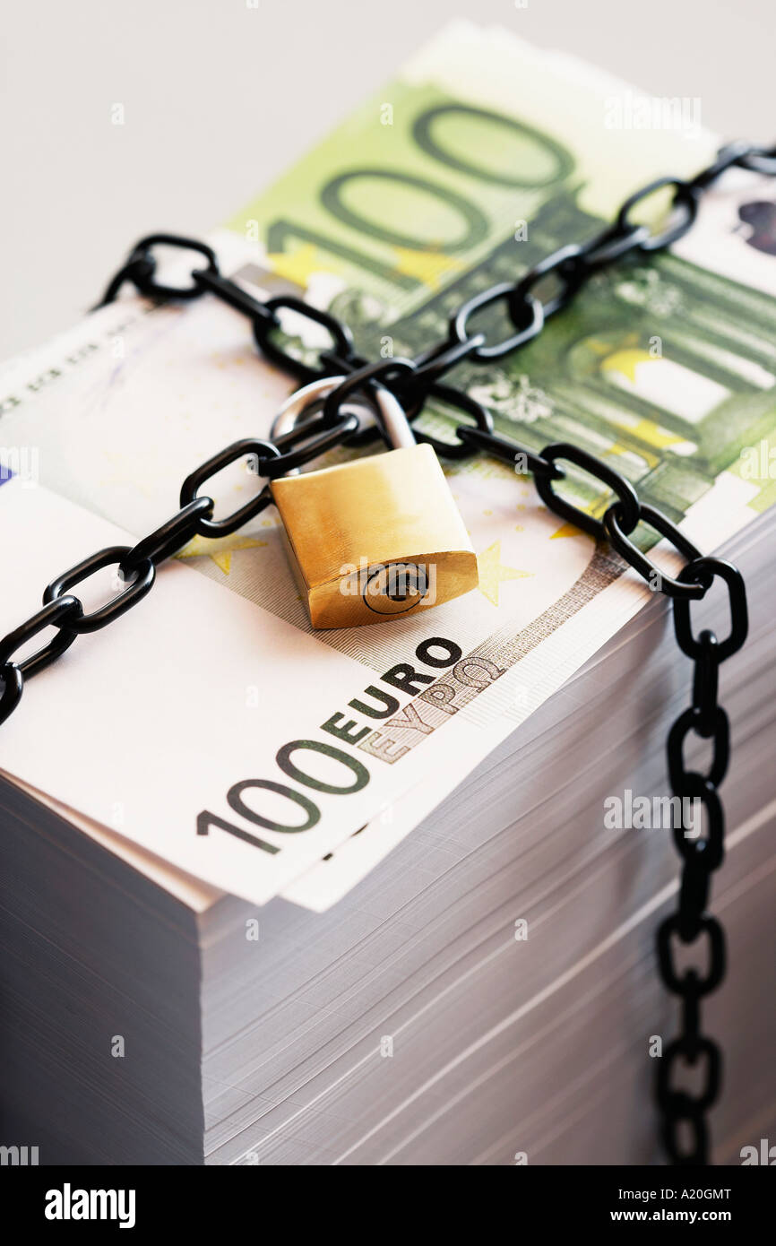 Stack of Euros secured by padlock and chain Stock Photo - Alamy