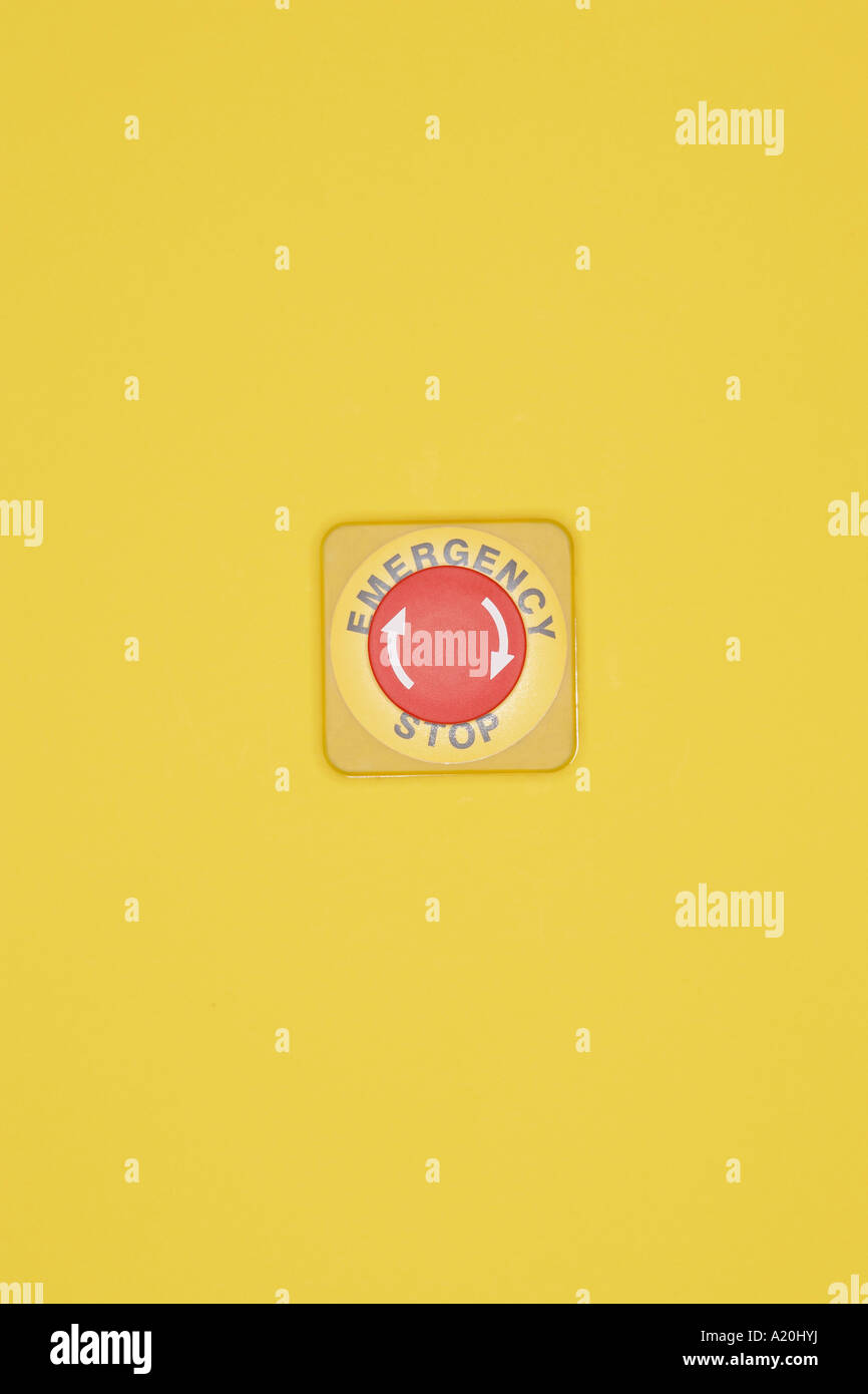Emergency stop button on yellow wall Stock Photo - Alamy
