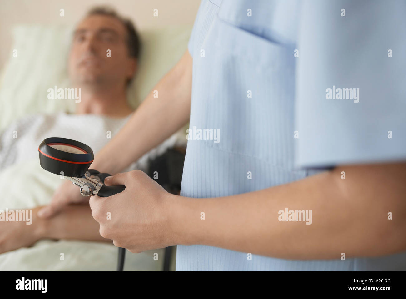 Nurse Taking blood pressure and pulse of patient in hospital bed, mid ...
