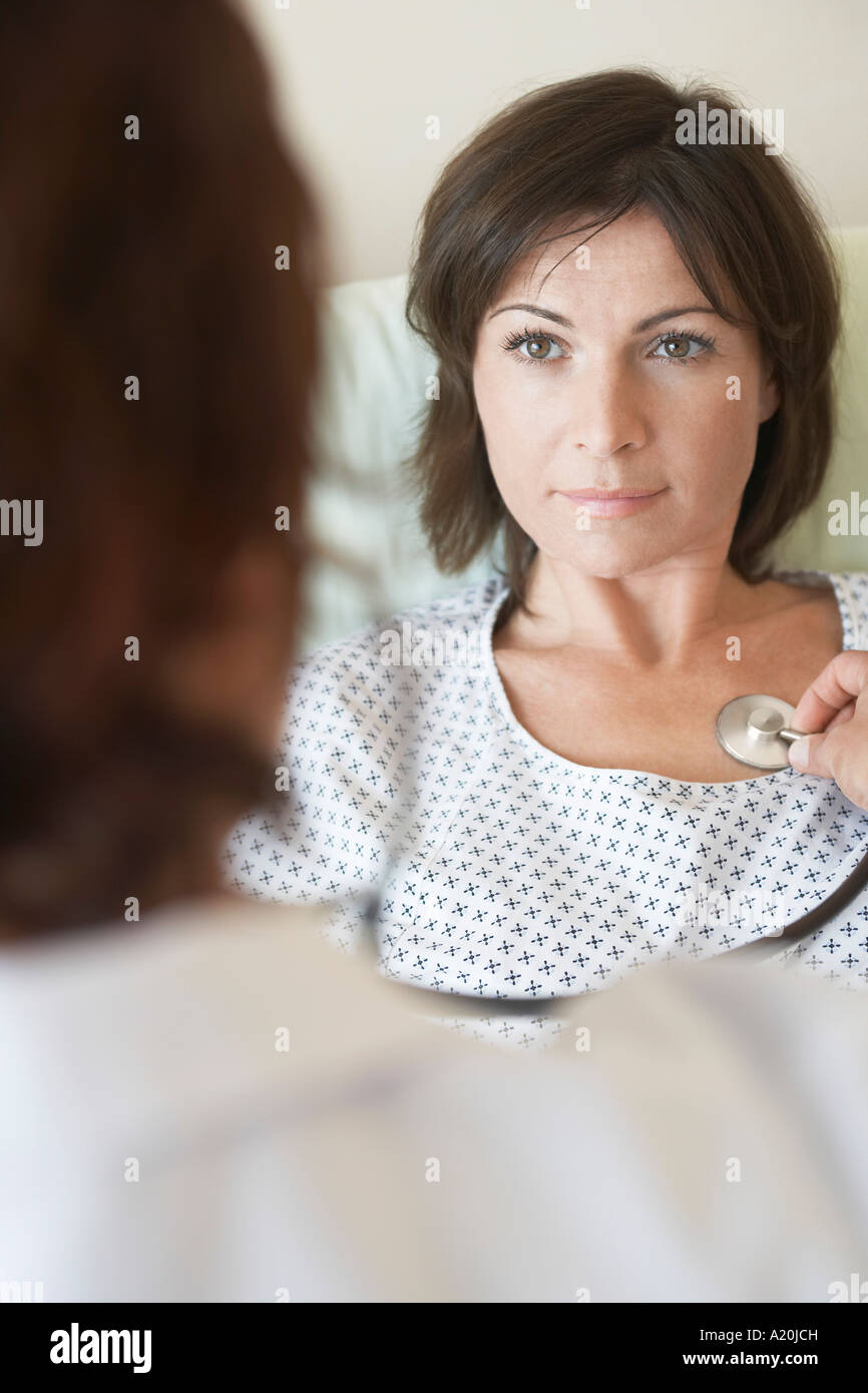 Doctor using stethoscope on chest of patient, back view of doctor ...