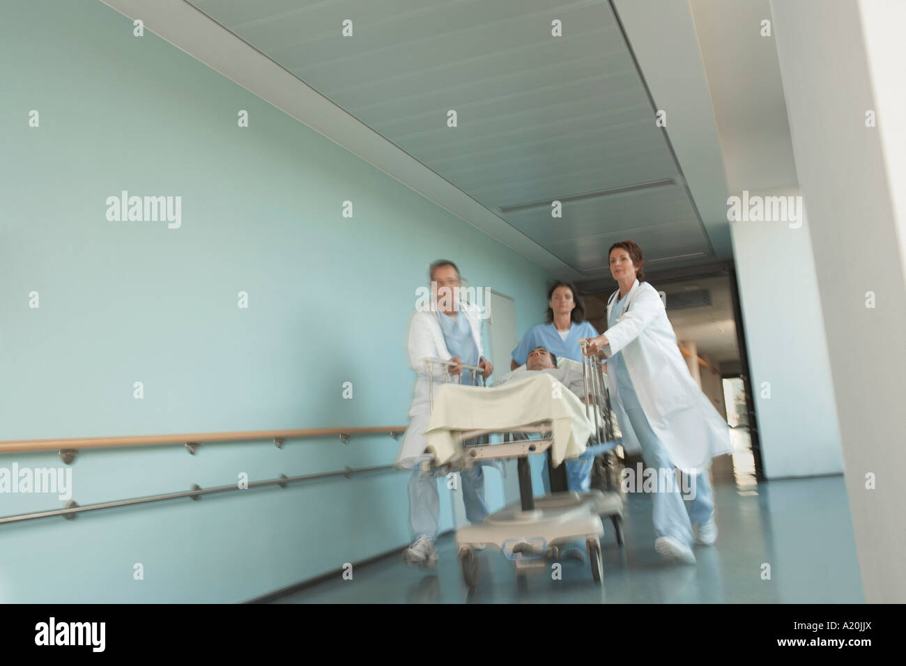 Physicians Rushing Patient on gurney Down hospital Corridor Stock Photo ...